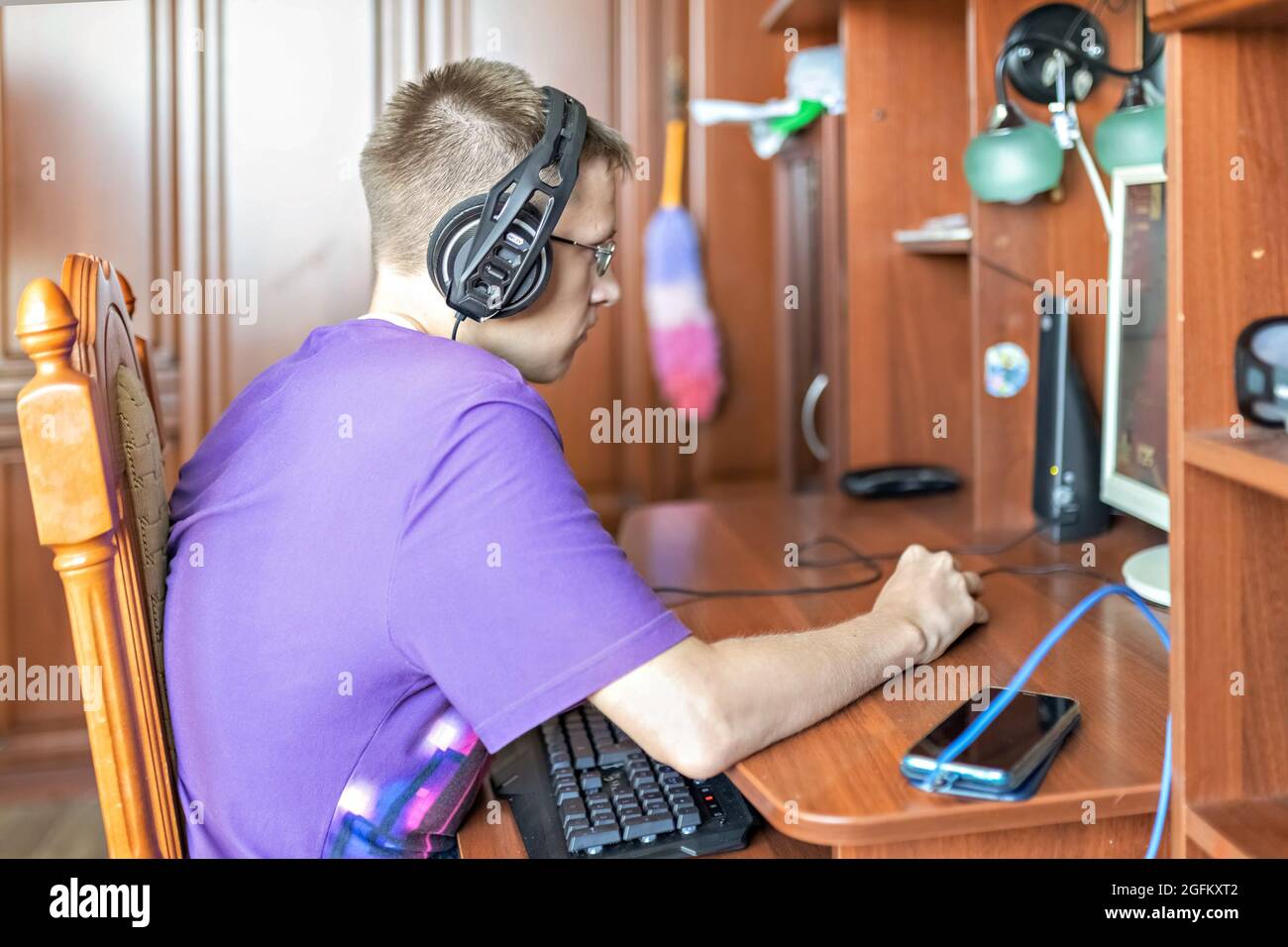 A teenage boy, a young man playing video games on a computer, using ...