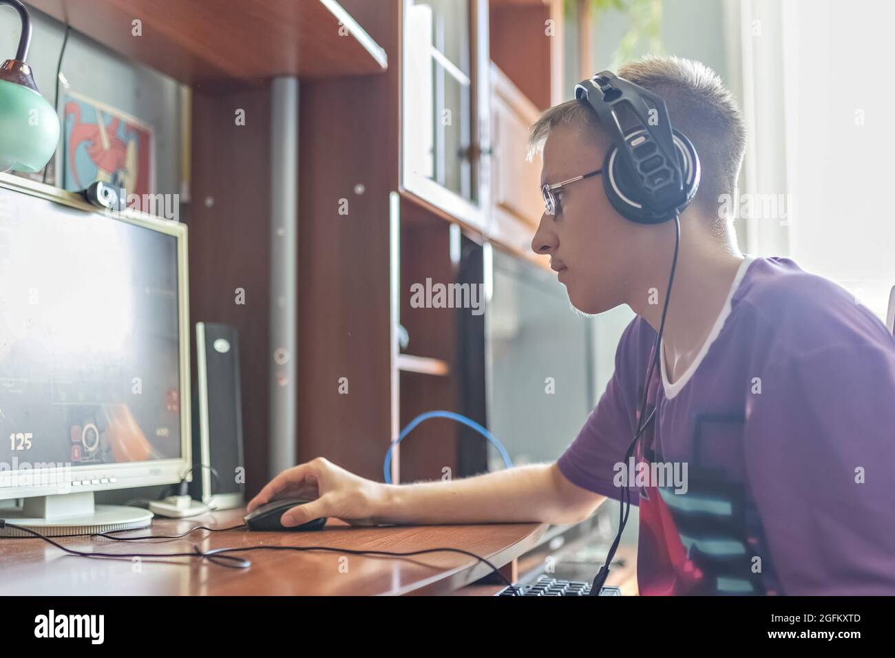 A teenage boy, a young man playing video games on a computer, using ...