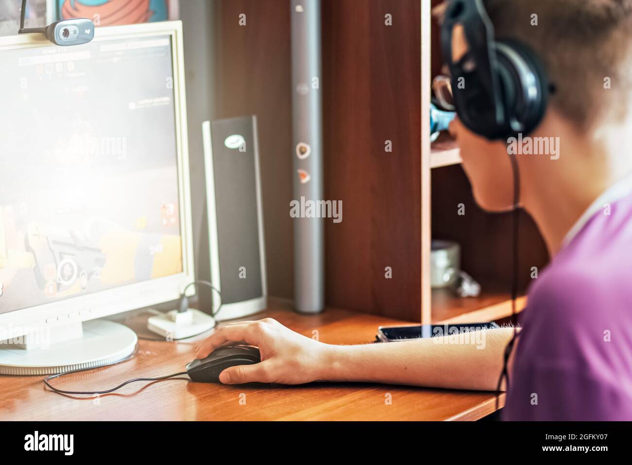 A teenage boy, a young man playing video games on a computer, using ...