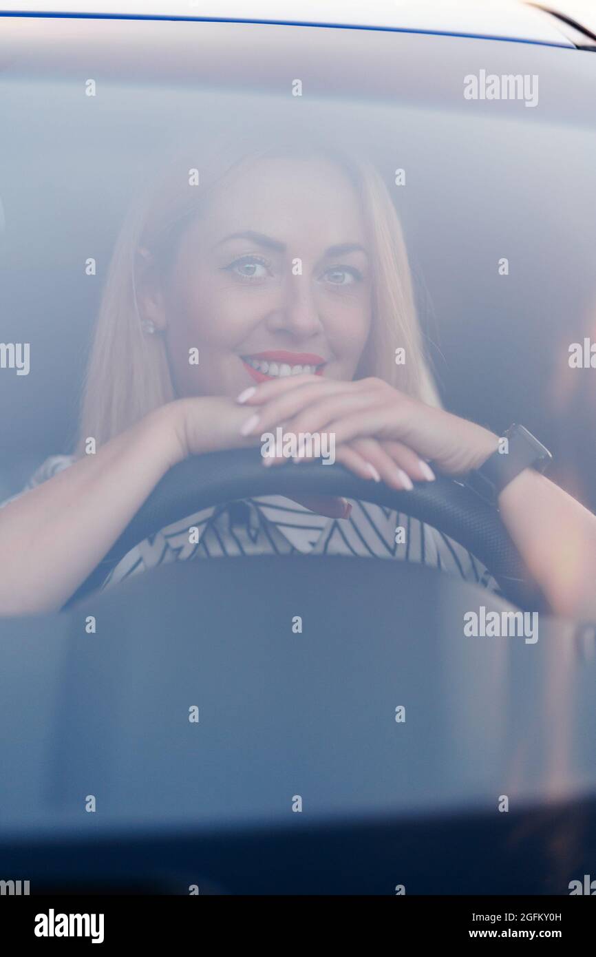 Portrait of lady in car. Young beautiful woman driving. Front view ...