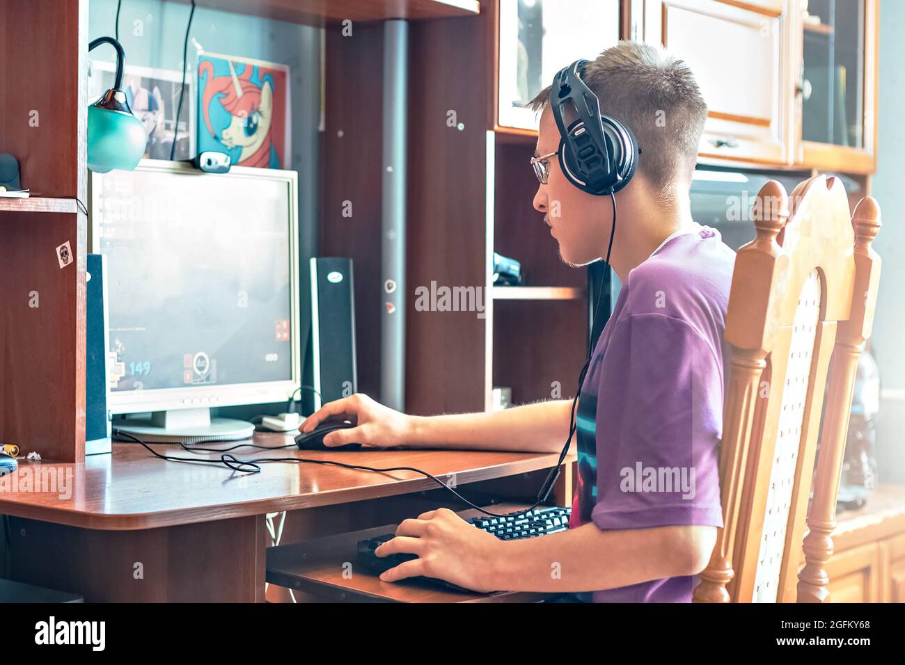 A teenage boy, a young man playing video games on a computer, using ...