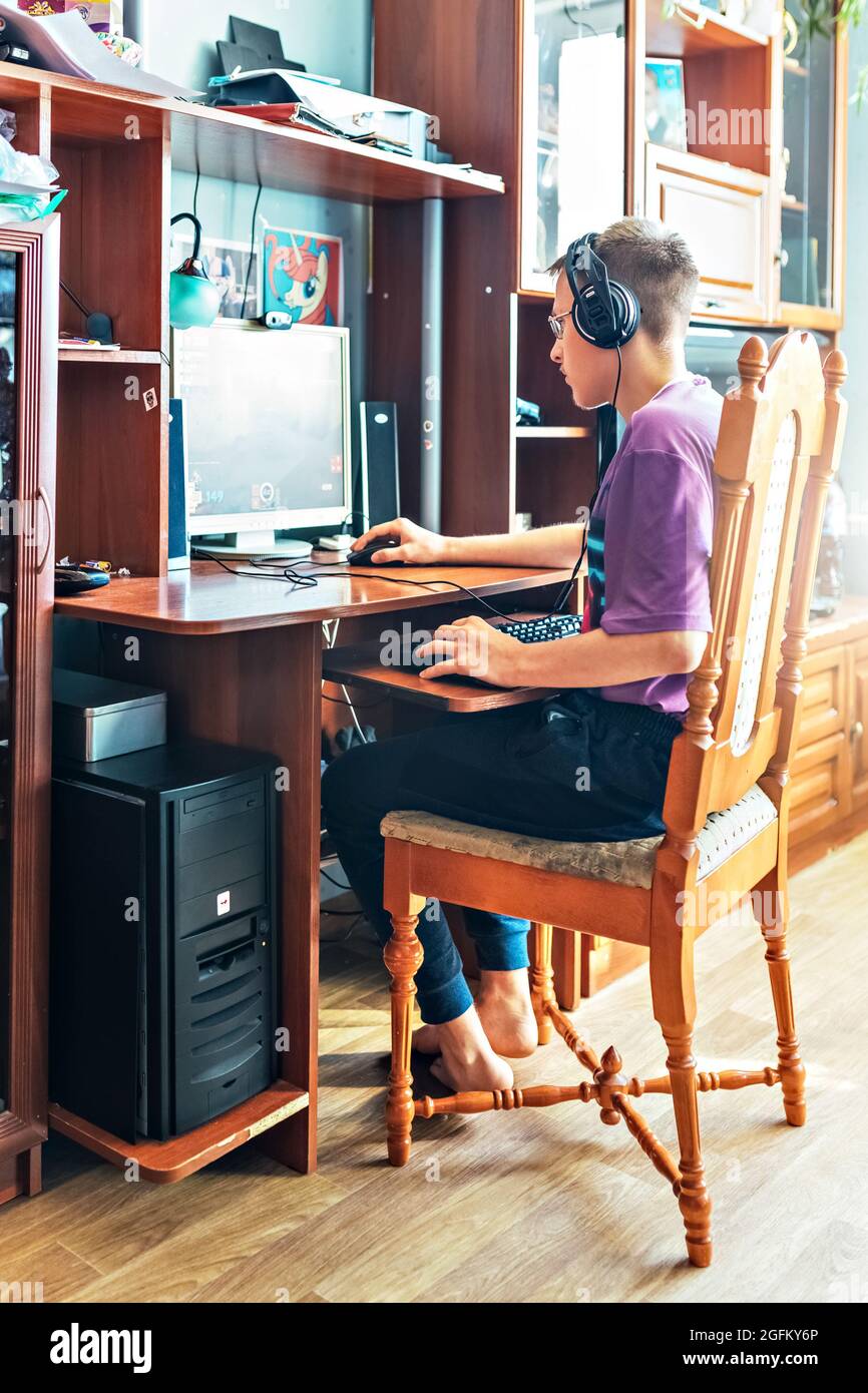 A teenage boy, a young man playing video games on a computer, using ...