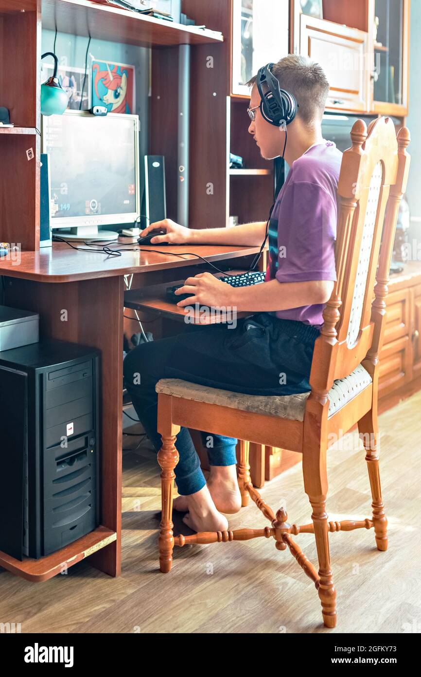 A teenage boy, a young man playing video games on a computer, using ...