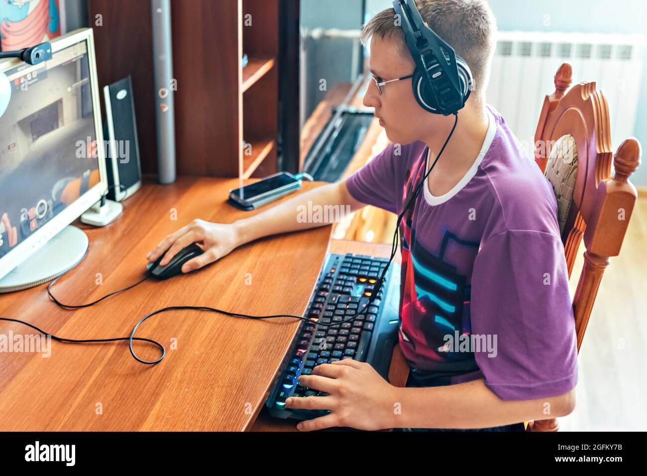 A teenage boy, a young man playing video games on a computer, using ...