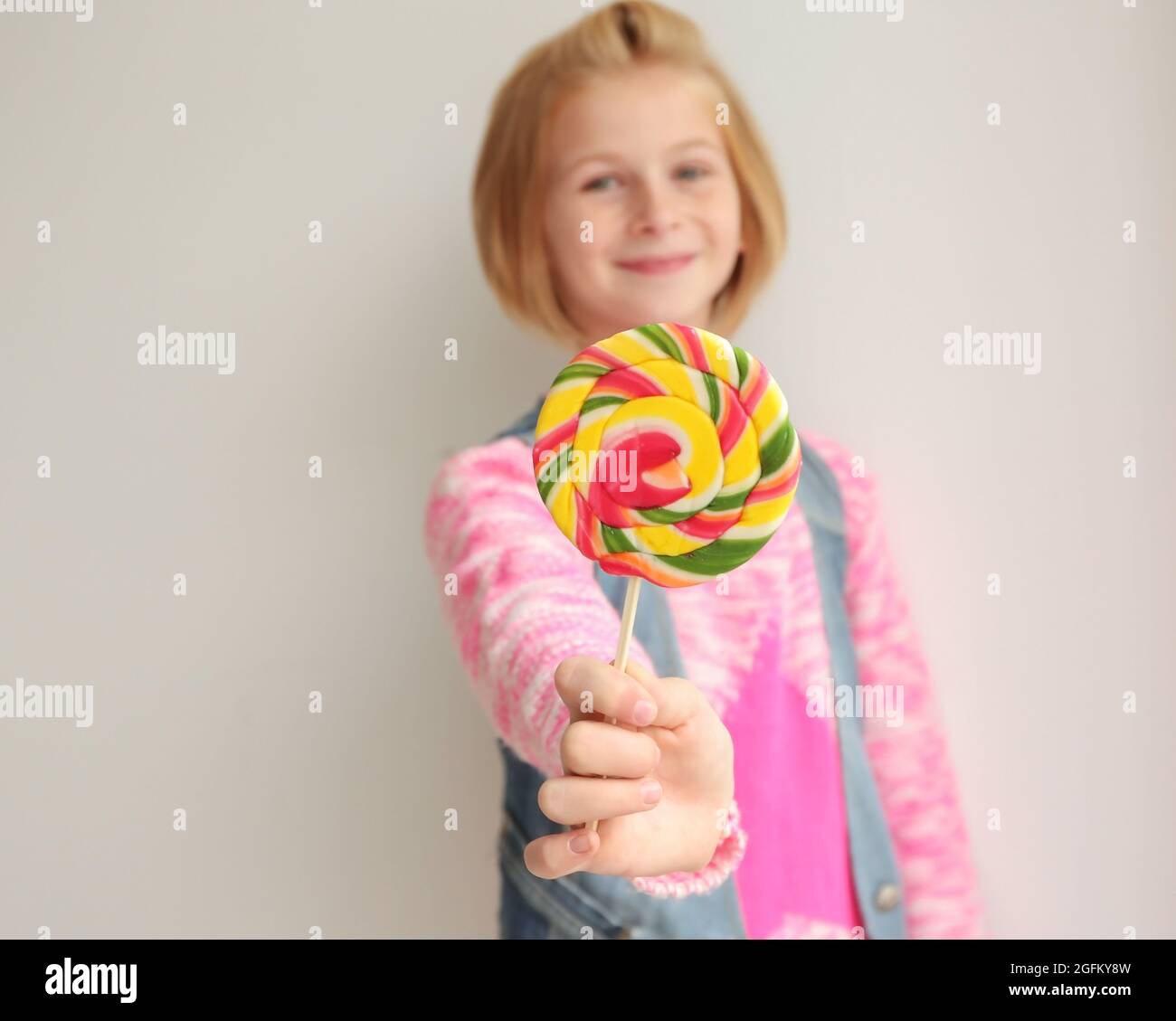 Funny teenager girl holding colourful lollipop on white background ...