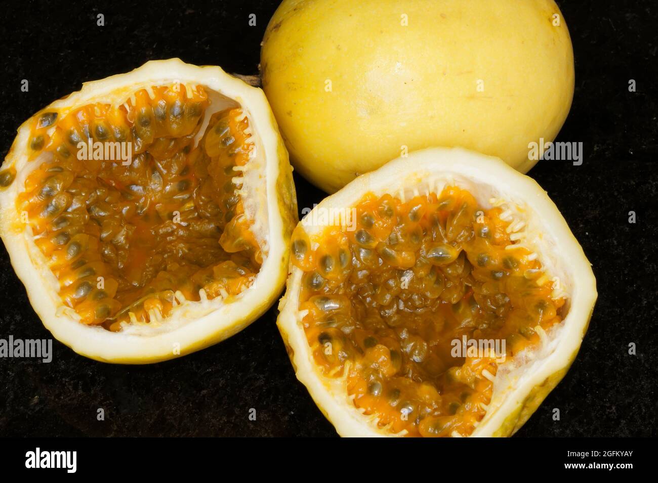 Passion fruit cut to make a juice with a black granite background Stock ...