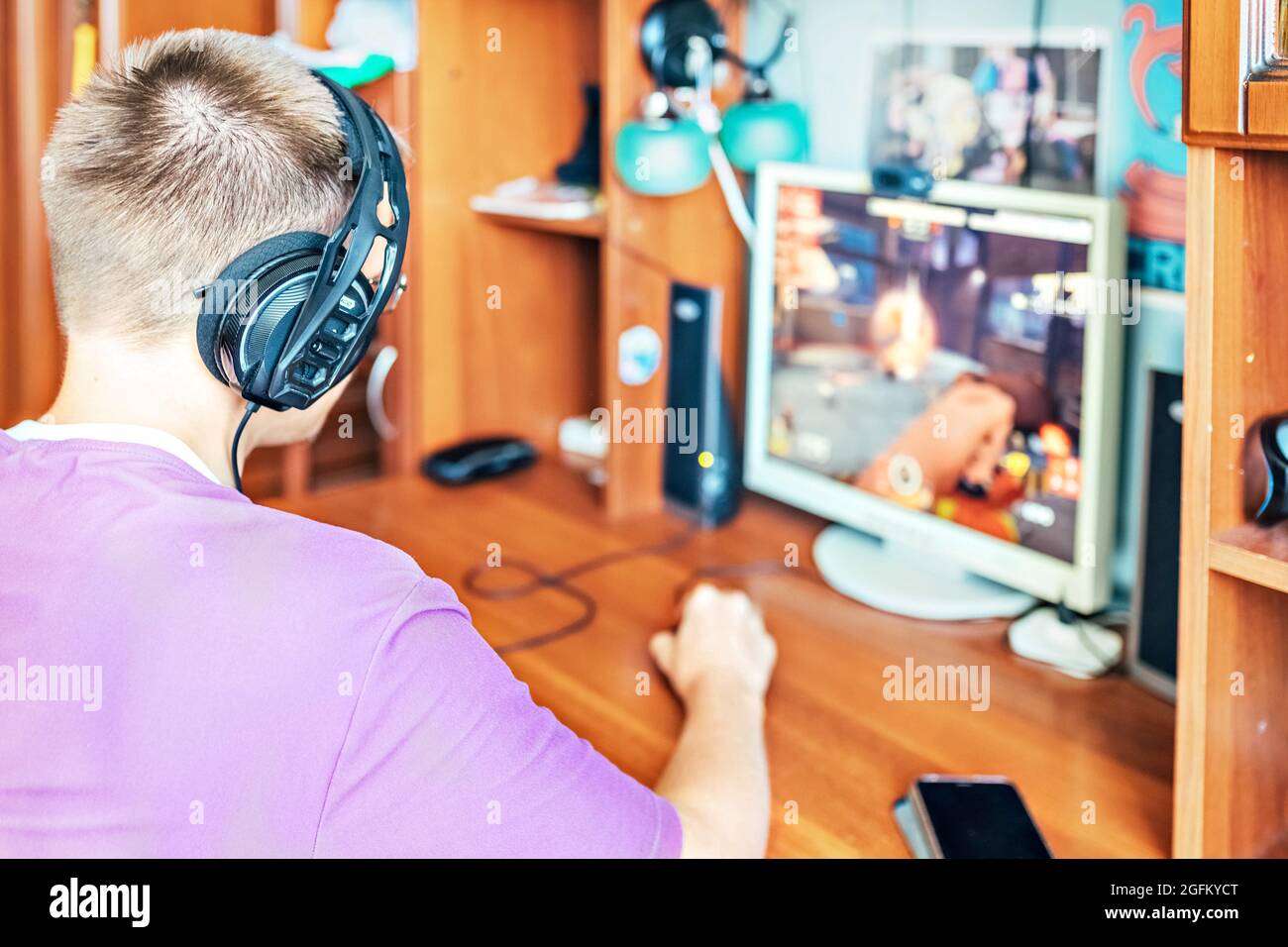 A teenage boy, a young man playing video games on a computer, using ...