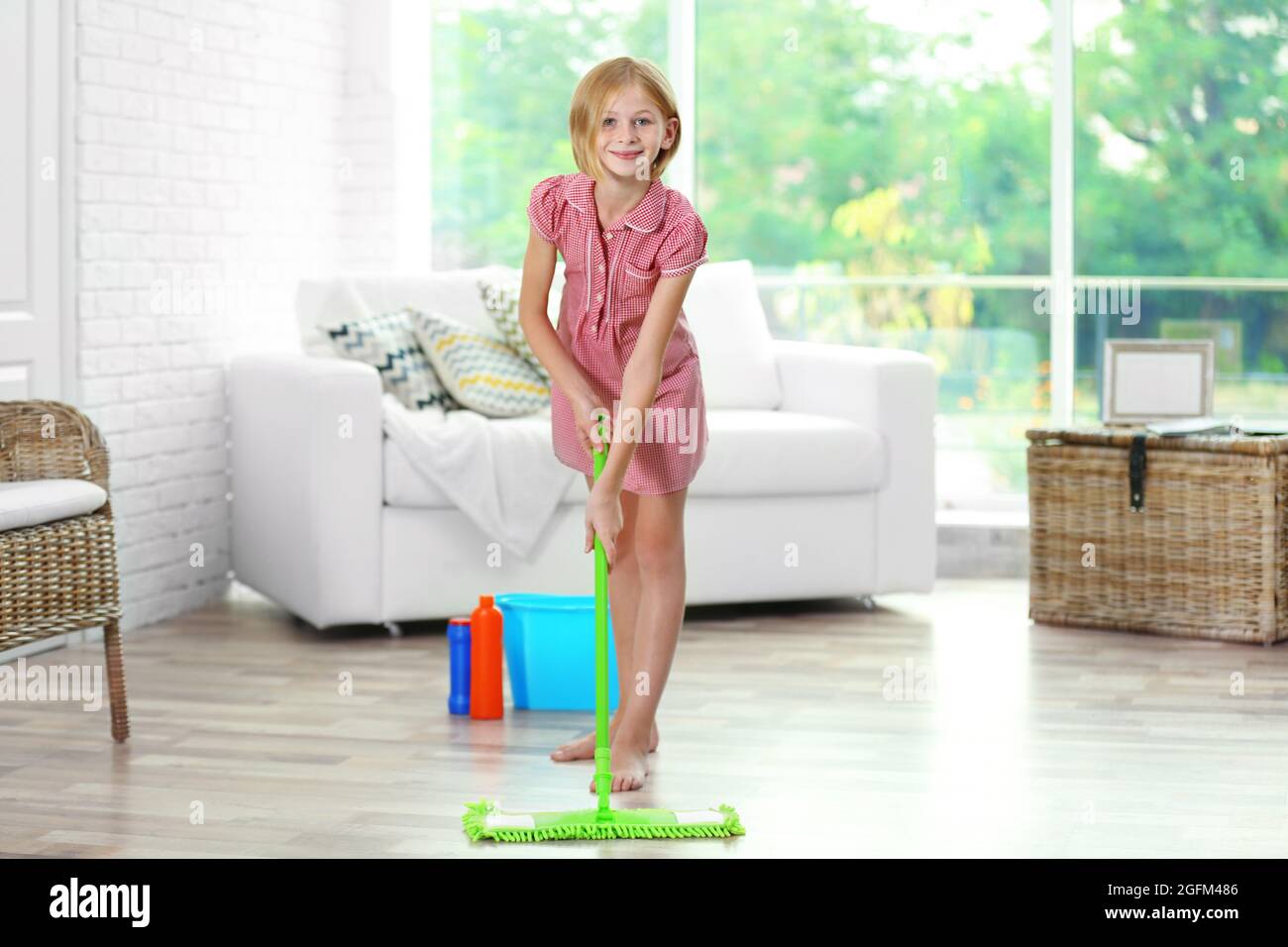 Small girl cleaning room with mop on light background Stock Photo - Alamy