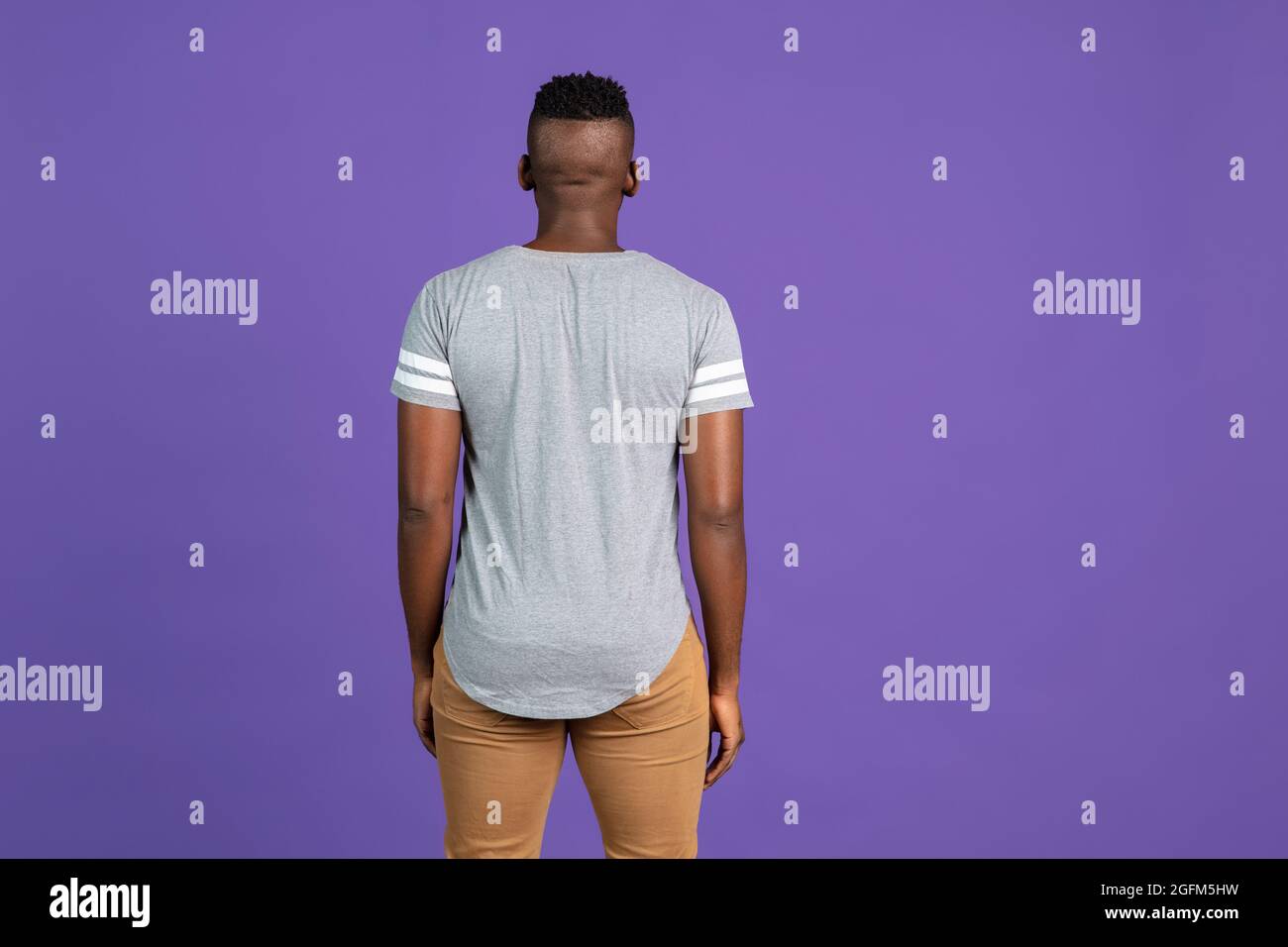 Back view of African-american young man's portrait on purple color ...
