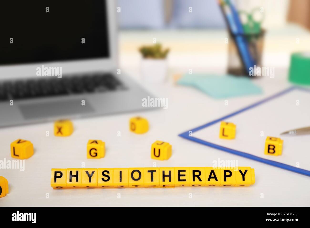 Word Physiotherapy on table with laptop and clipboard Stock Photo - Alamy