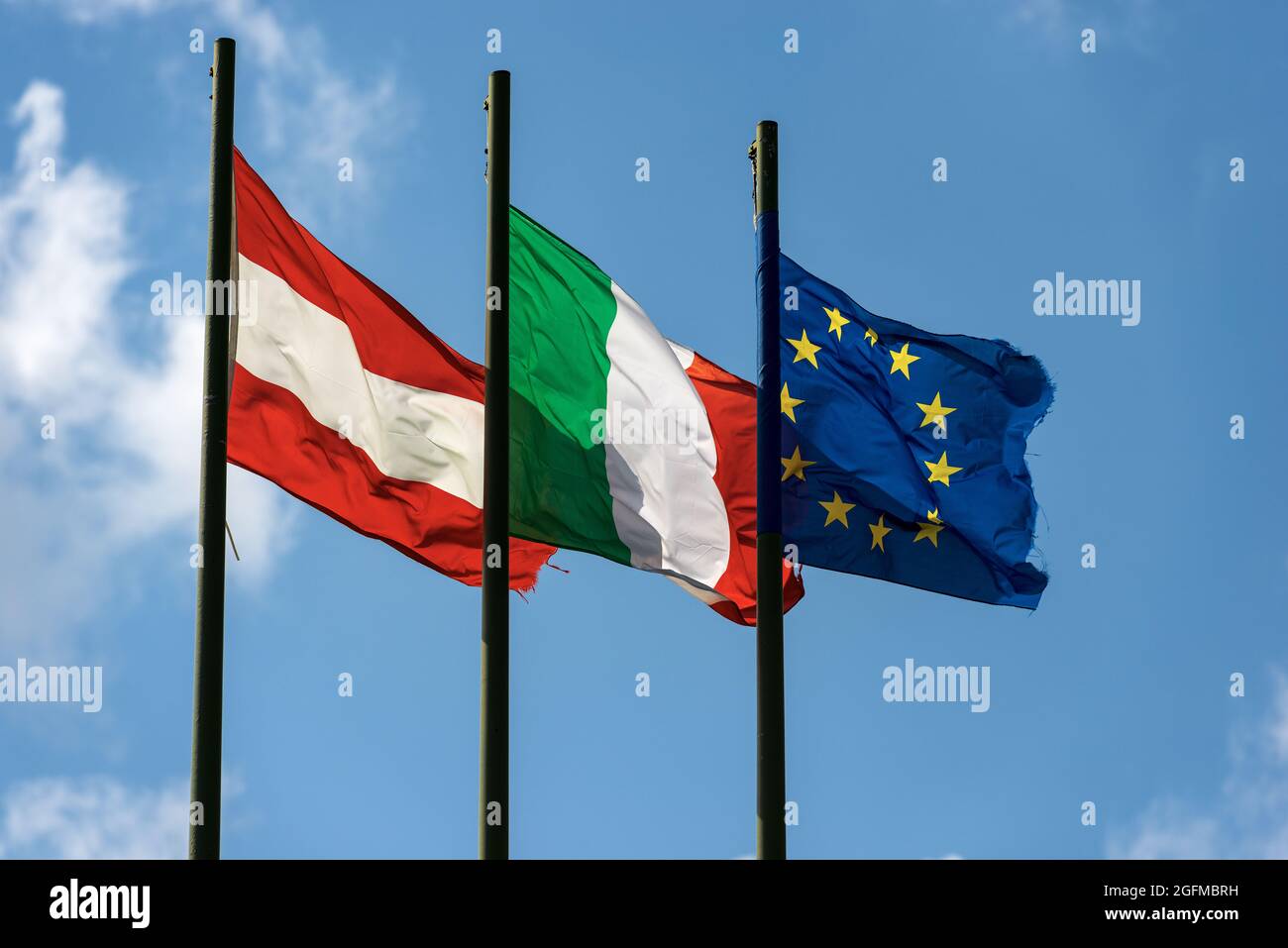 Austrian, Italian and European Union flags with flagpole, blowing ...