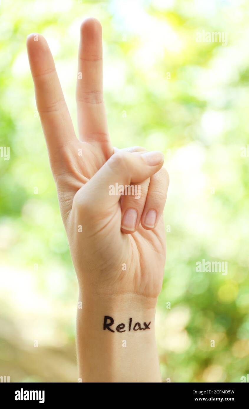 Female hand with tattoo word RELAX, outdoor Stock Photo - Alamy