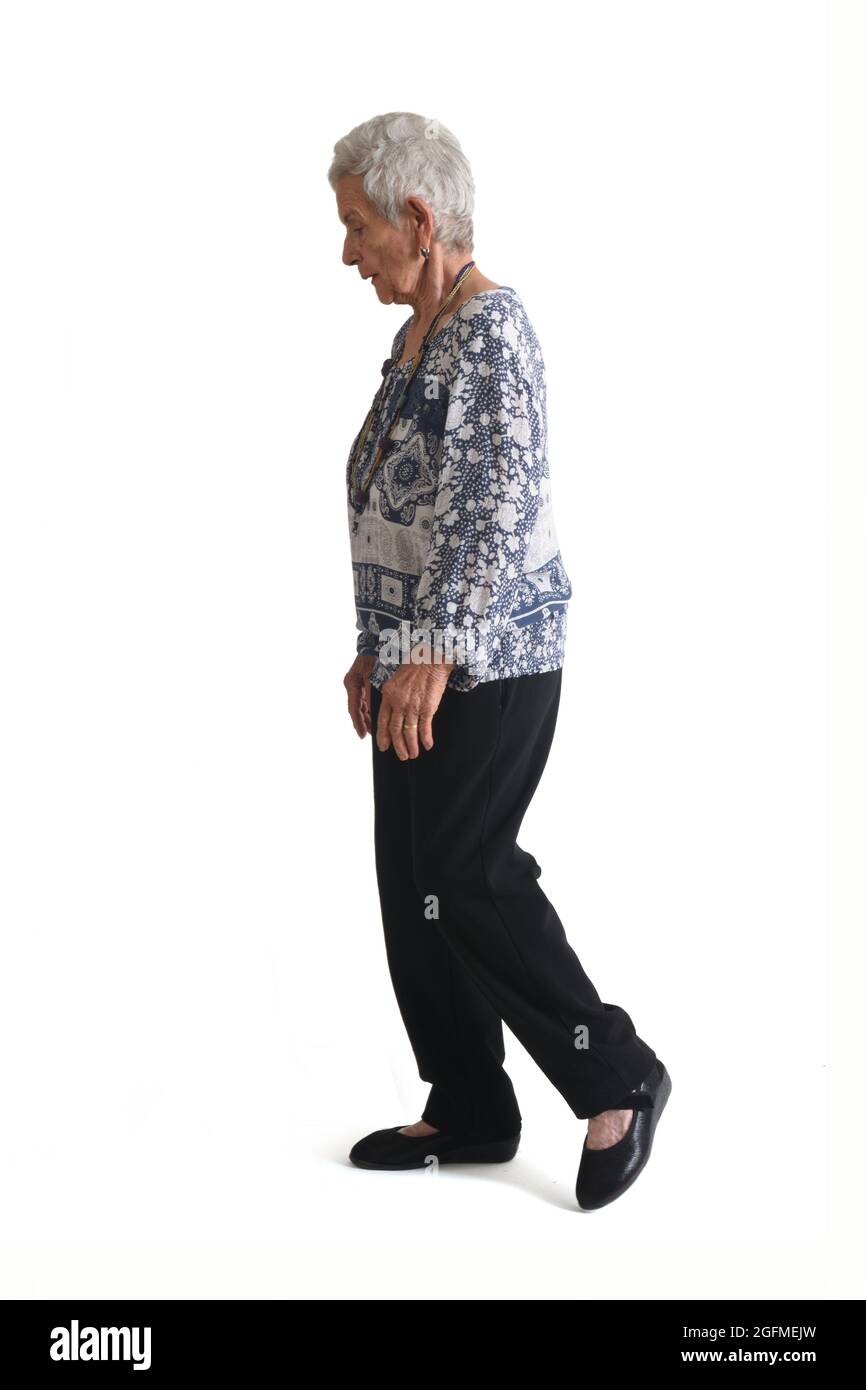 full portrait of a senior woman side view, walking on white background ...