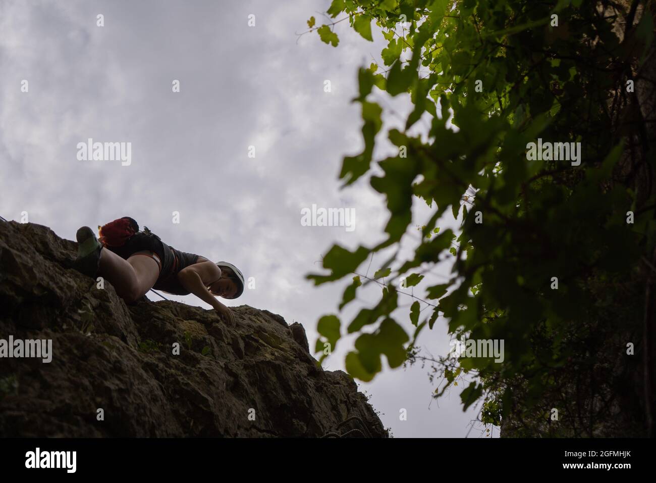 Beatiful girl climbing to the top of the high hill while thinking a lot ...