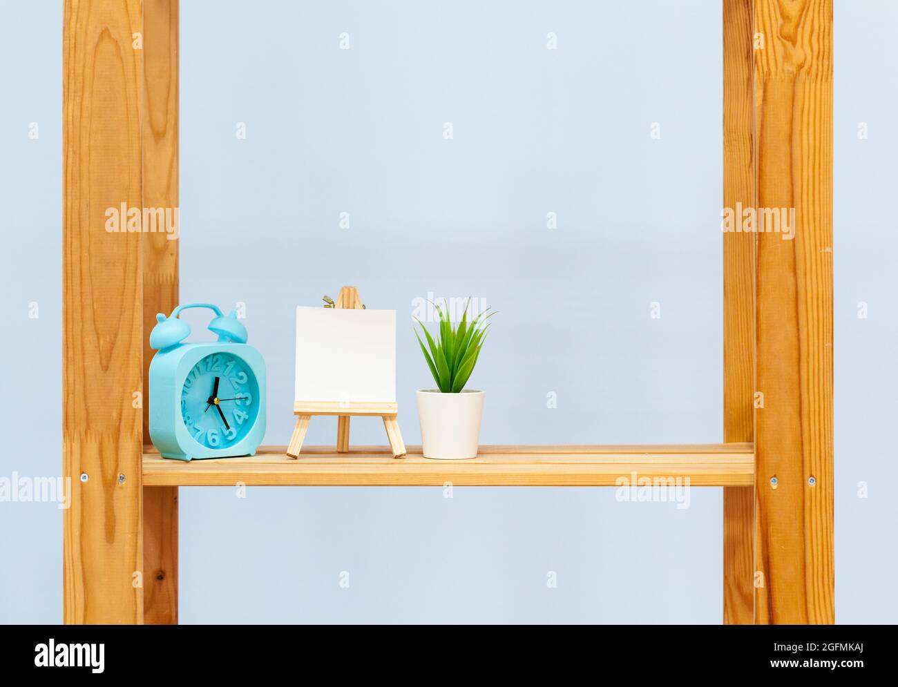 Wooden shelf with alarm clock and objects against blue background Stock ...