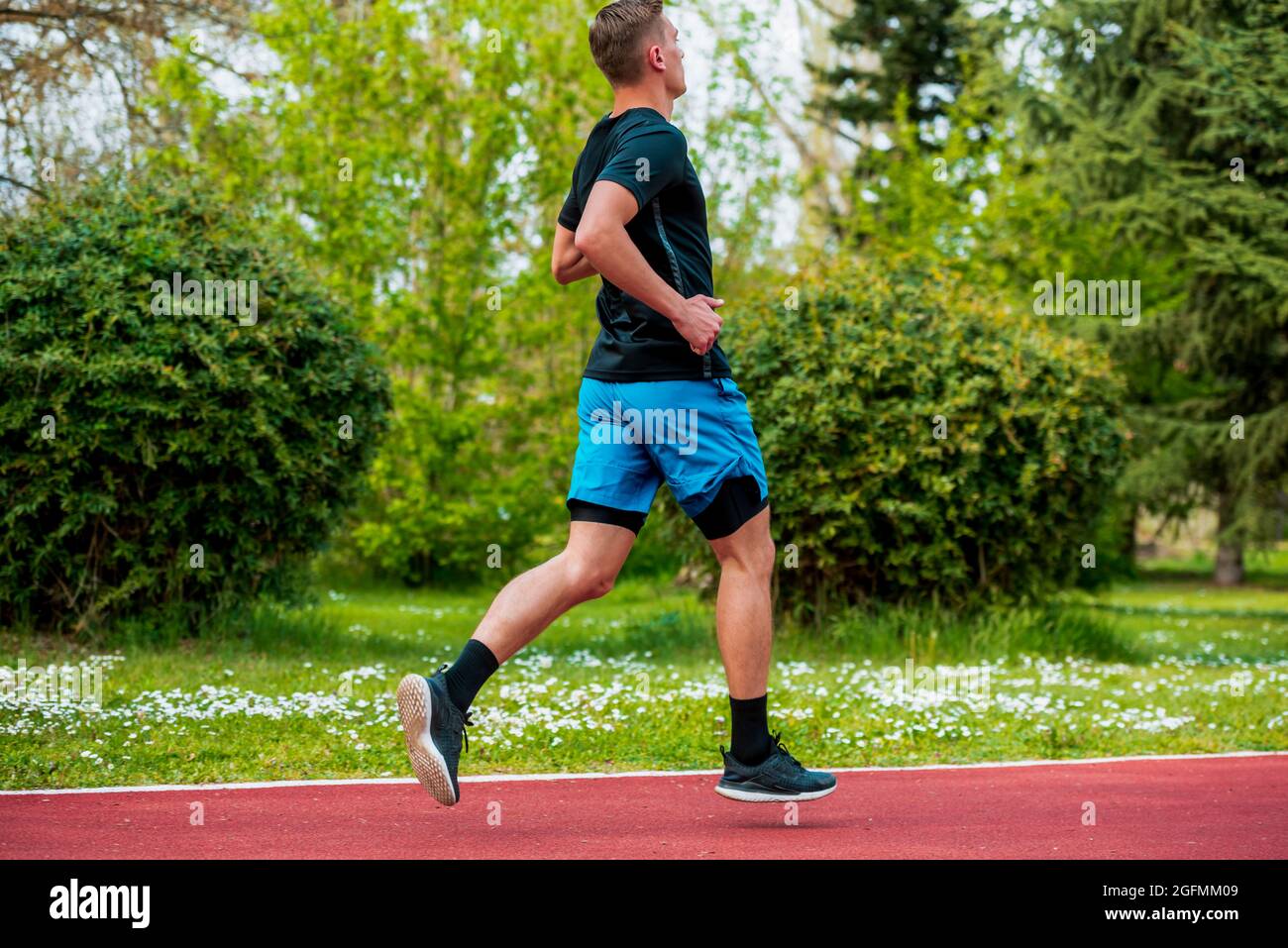 Runner jogging along a pathway in a park outdoors healthy wellness ...