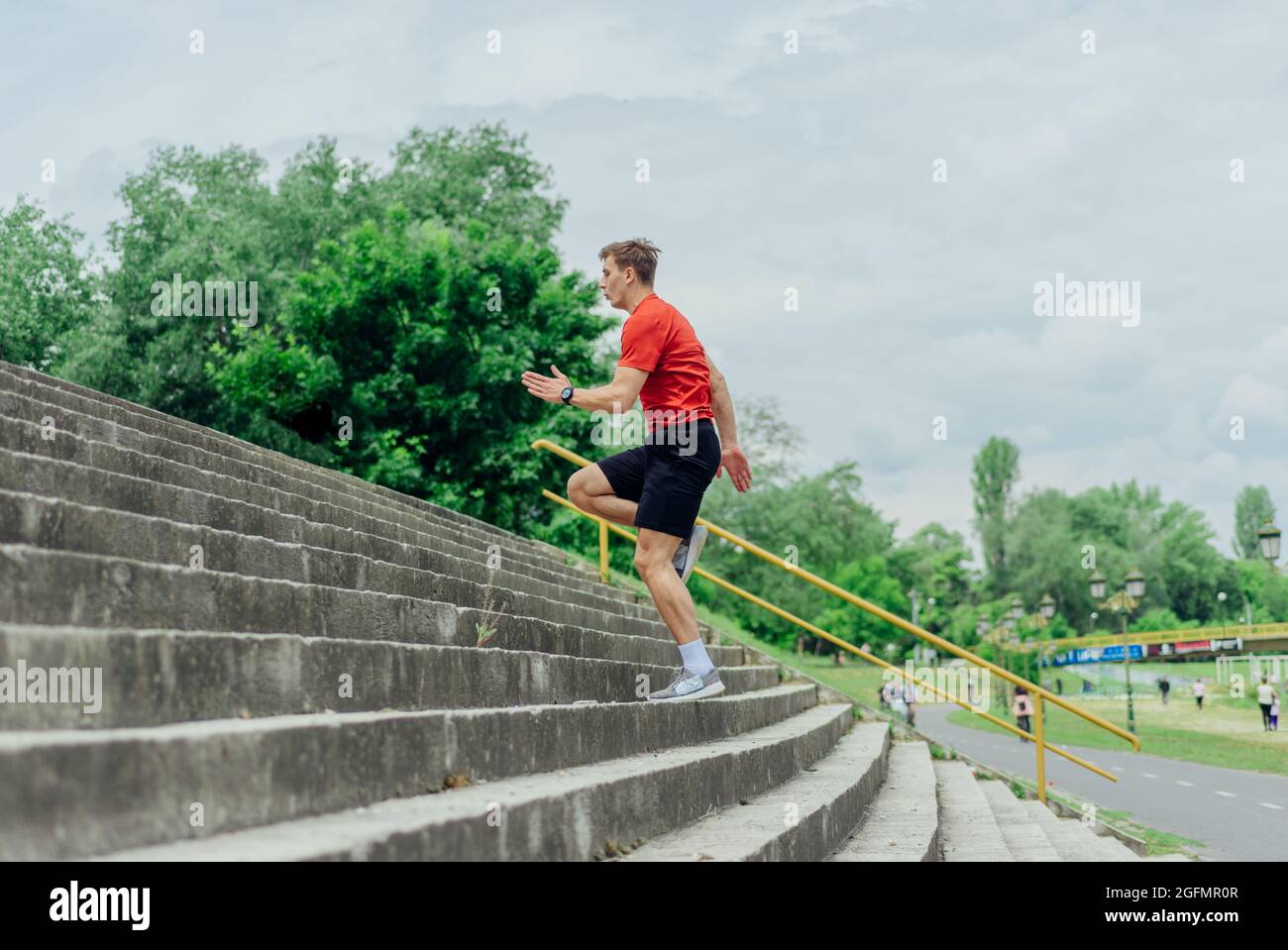 Fit male athlete performing stairs workout, running up climbing stairs ...