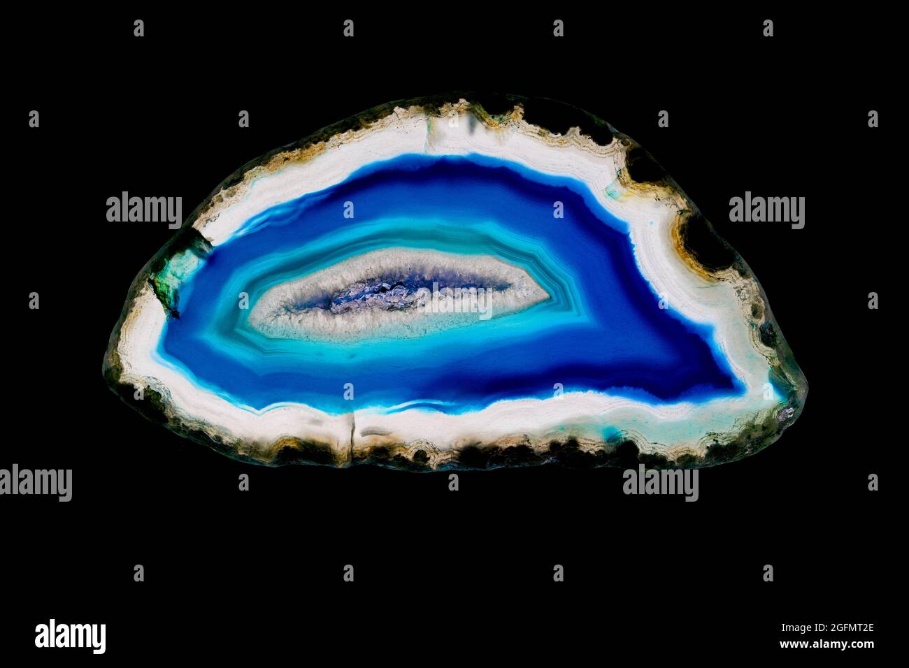 Brightly coloured stone slice photographed against a plain black ...