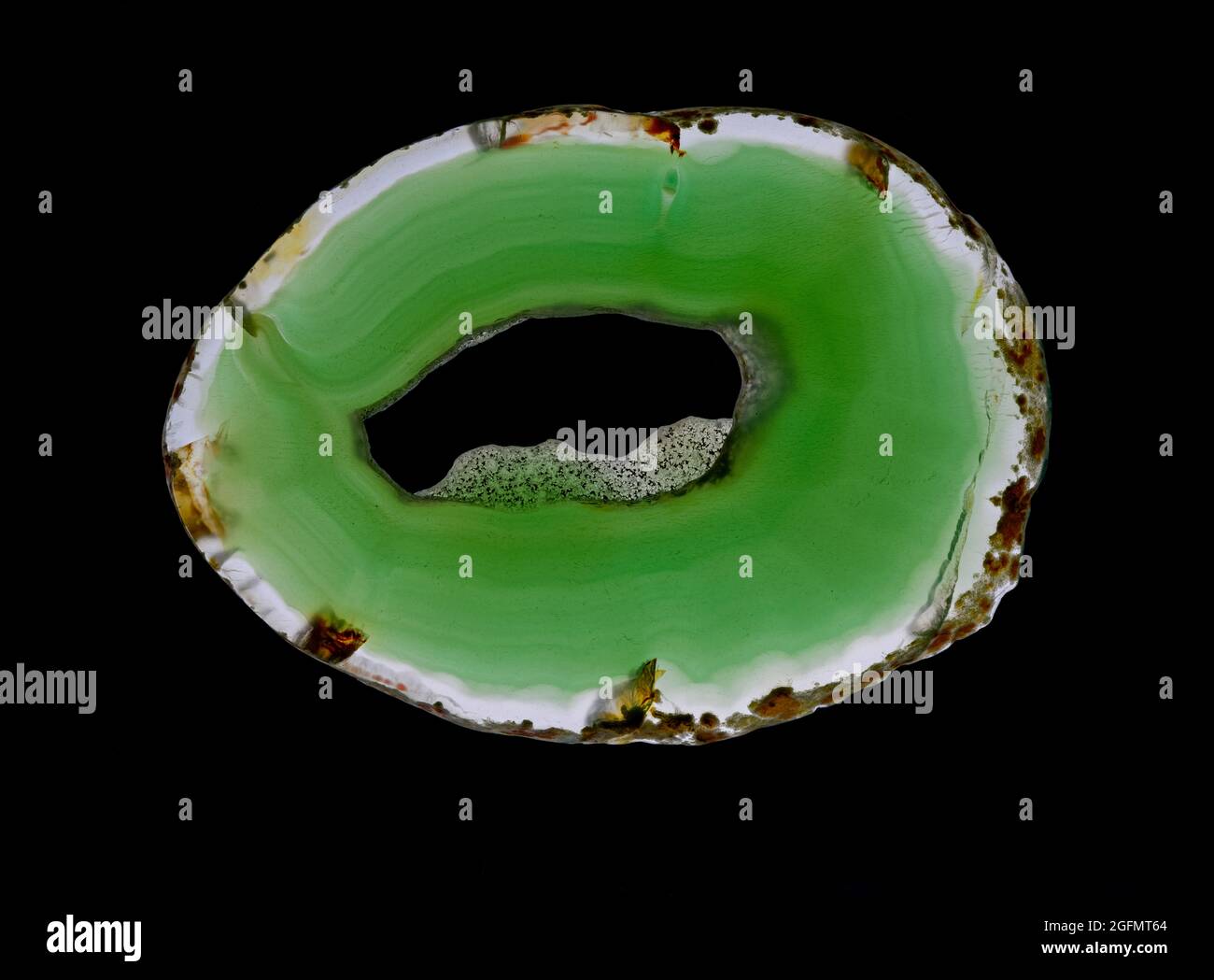 Brightly coloured stone slice photographed against a plain black ...