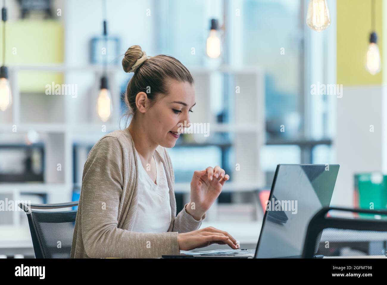 Blonde manager working behind her desk in a modern office Stock Photo ...
