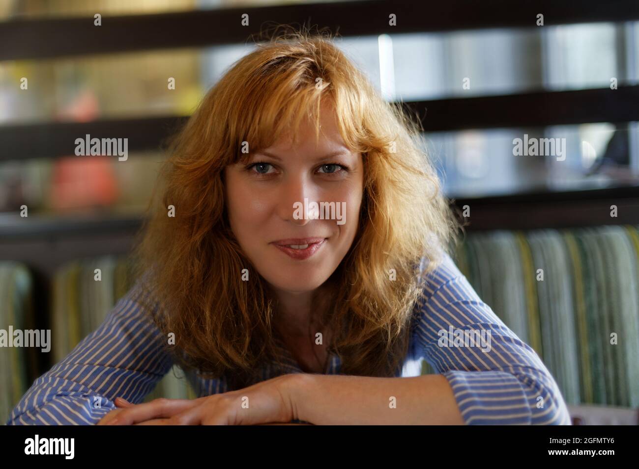 Girl looks straight ahead and smiling. Blurred background Stock Photo ...