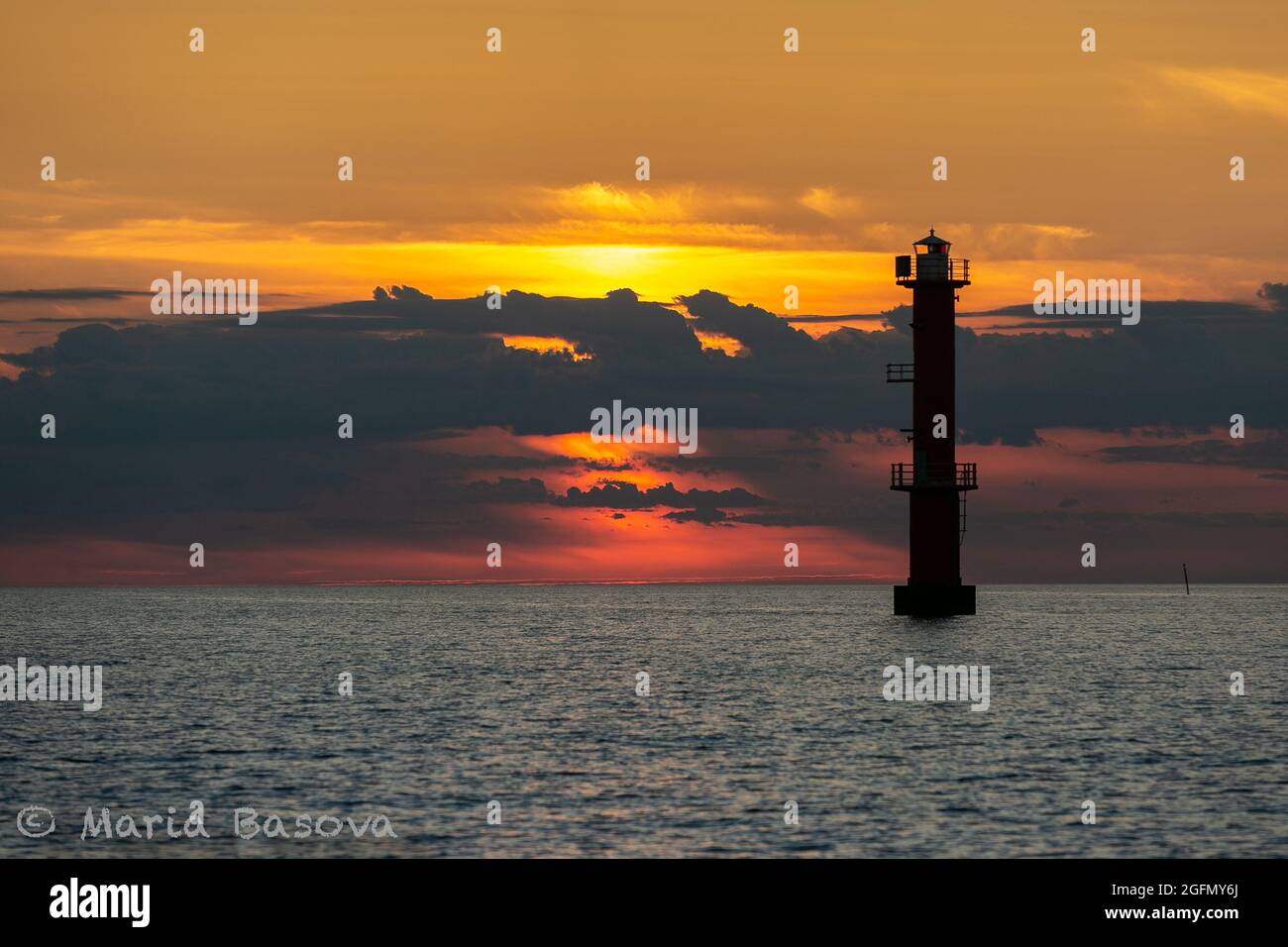 Lighthouse in the sea, sunset, seascape Stock Photo - Alamy