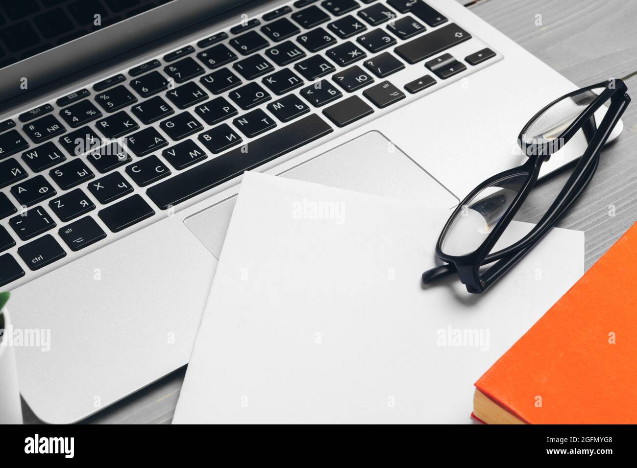Angled View of laptop Computer Keyboard and glasses with Various Office ...