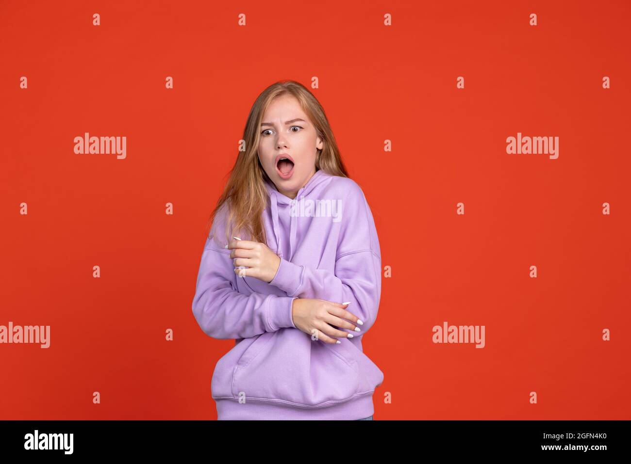 Half-length portrait of scared and shocked young girl isolated on red ...
