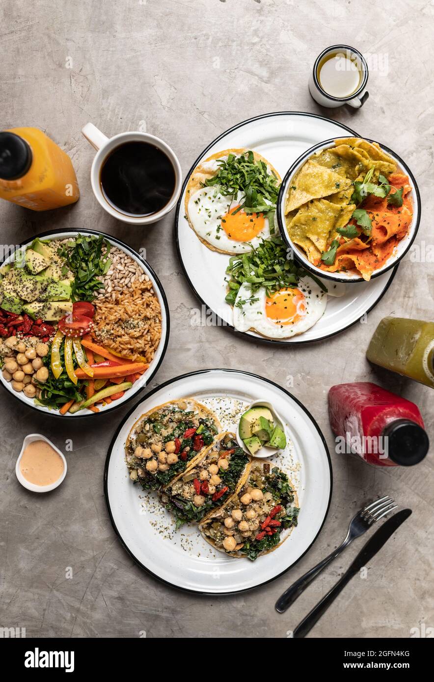 Vertical top view of various dishes with eggs, vegetables, and tacos ...