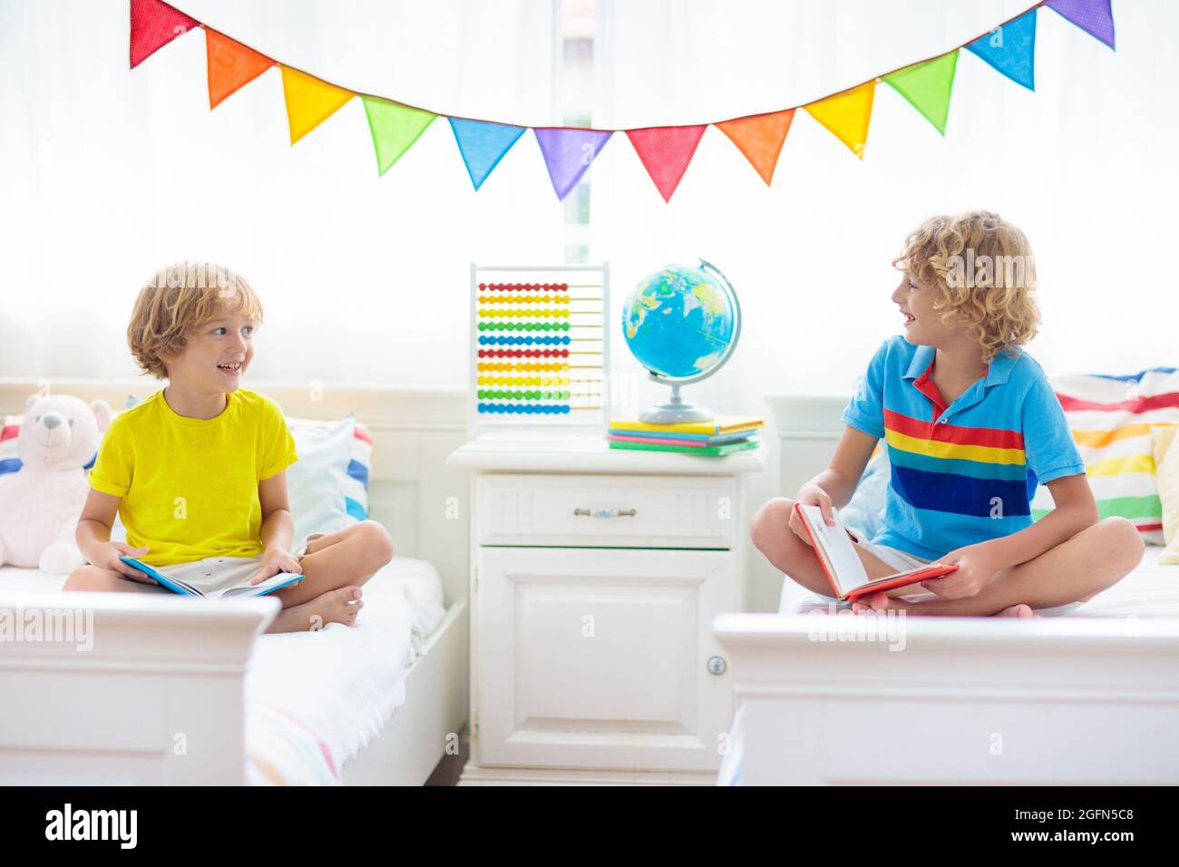 Child reading book in bed. Bedroom for two kids. Little boys read books ...