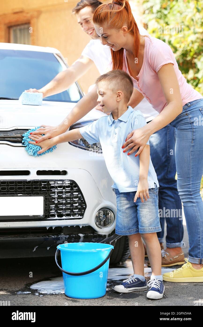 Happy family washing car on street Stock Photo - Alamy