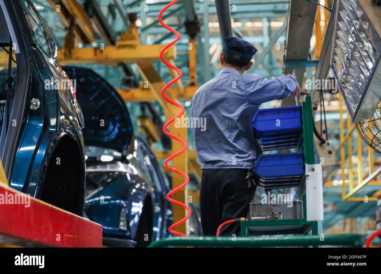 Workers assemble cars produced at a factory of Haima Automobile in ...