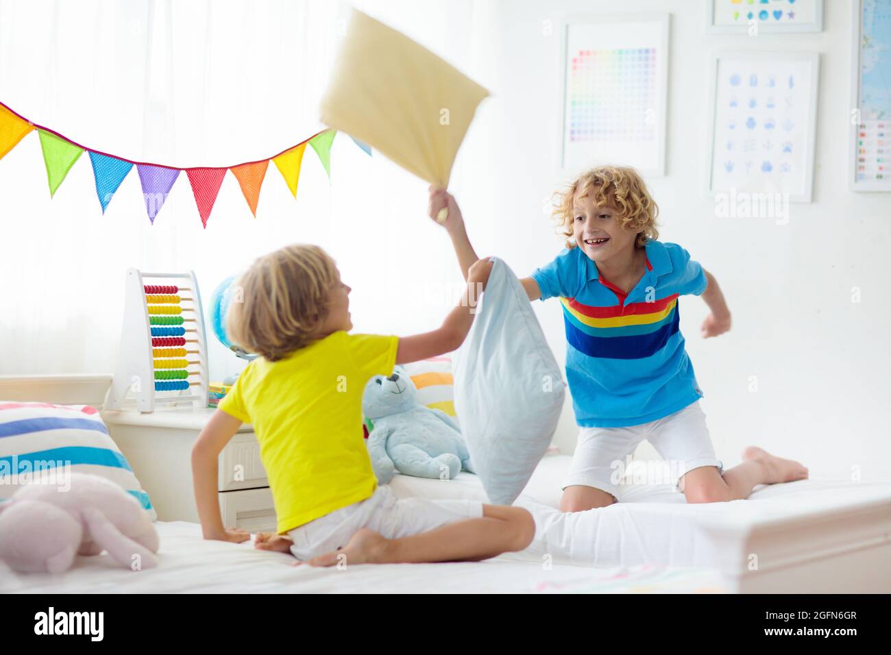 Kids pillow fight. Home family fun. Bedroom for two children with ...
