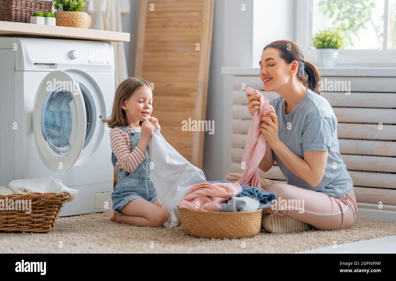 Beautiful young woman and child girl little helper are having fun and ...