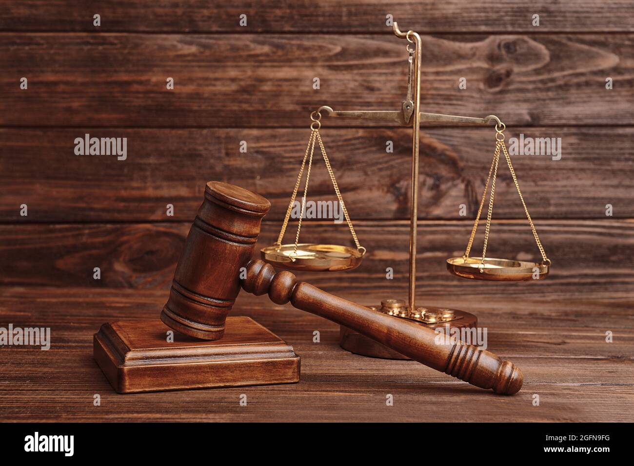 Judge's gavel and scales on wooden wall background Stock Photo - Alamy