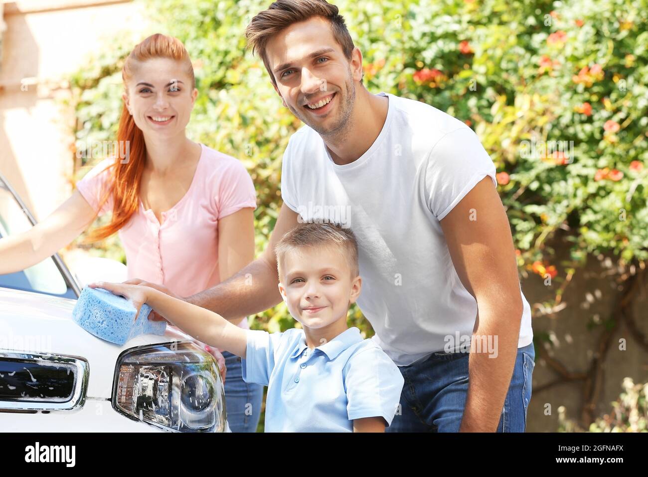 Happy family washing car on street Stock Photo - Alamy