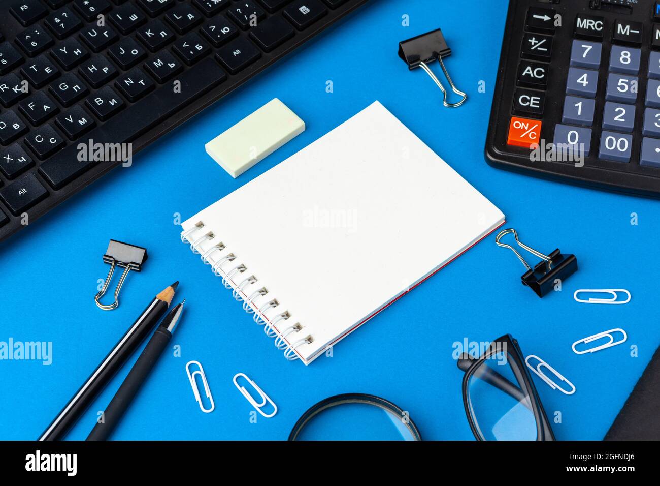 Flat lay, top view of blue office table desk. Workspace with blank note ...