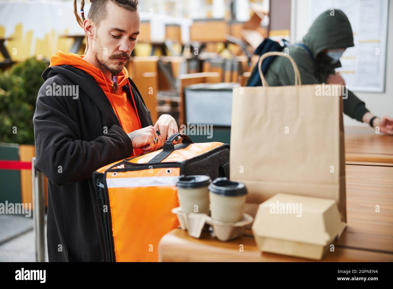 Concentrated man packing food into thermo backpack Stock Photo - Alamy