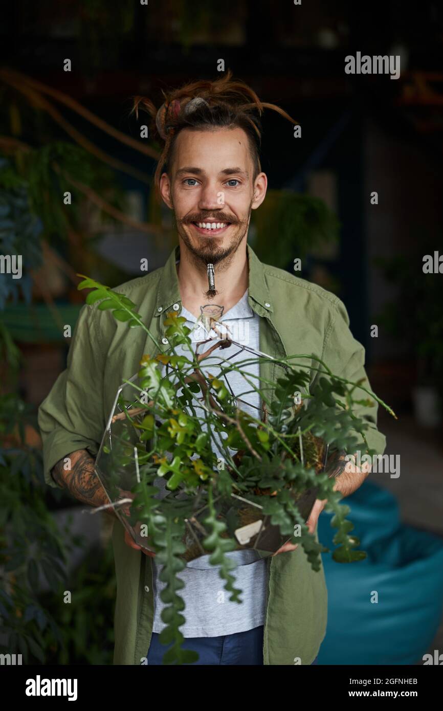 Joyful young man holding geometric glass terrarium Stock Photo - Alamy
