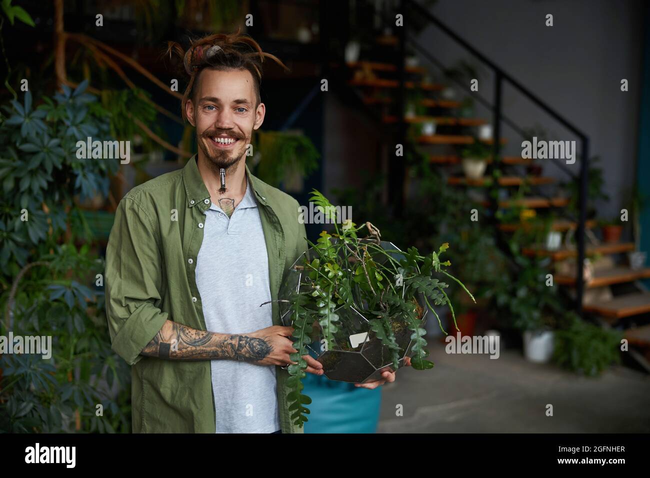 Cheerful young man holding geometric glass terrarium Stock Photo - Alamy