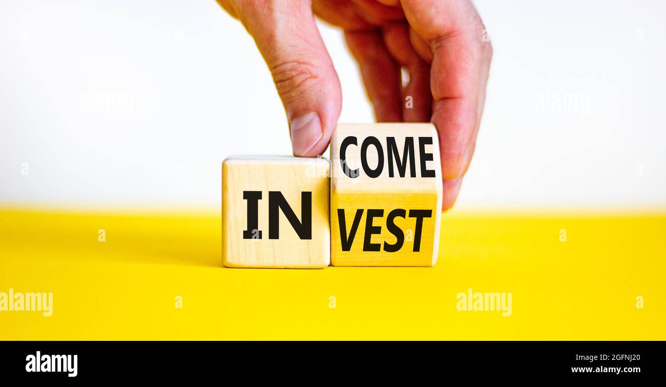 Invest or income symbol. Businessman turns a wooden cube and changes ...