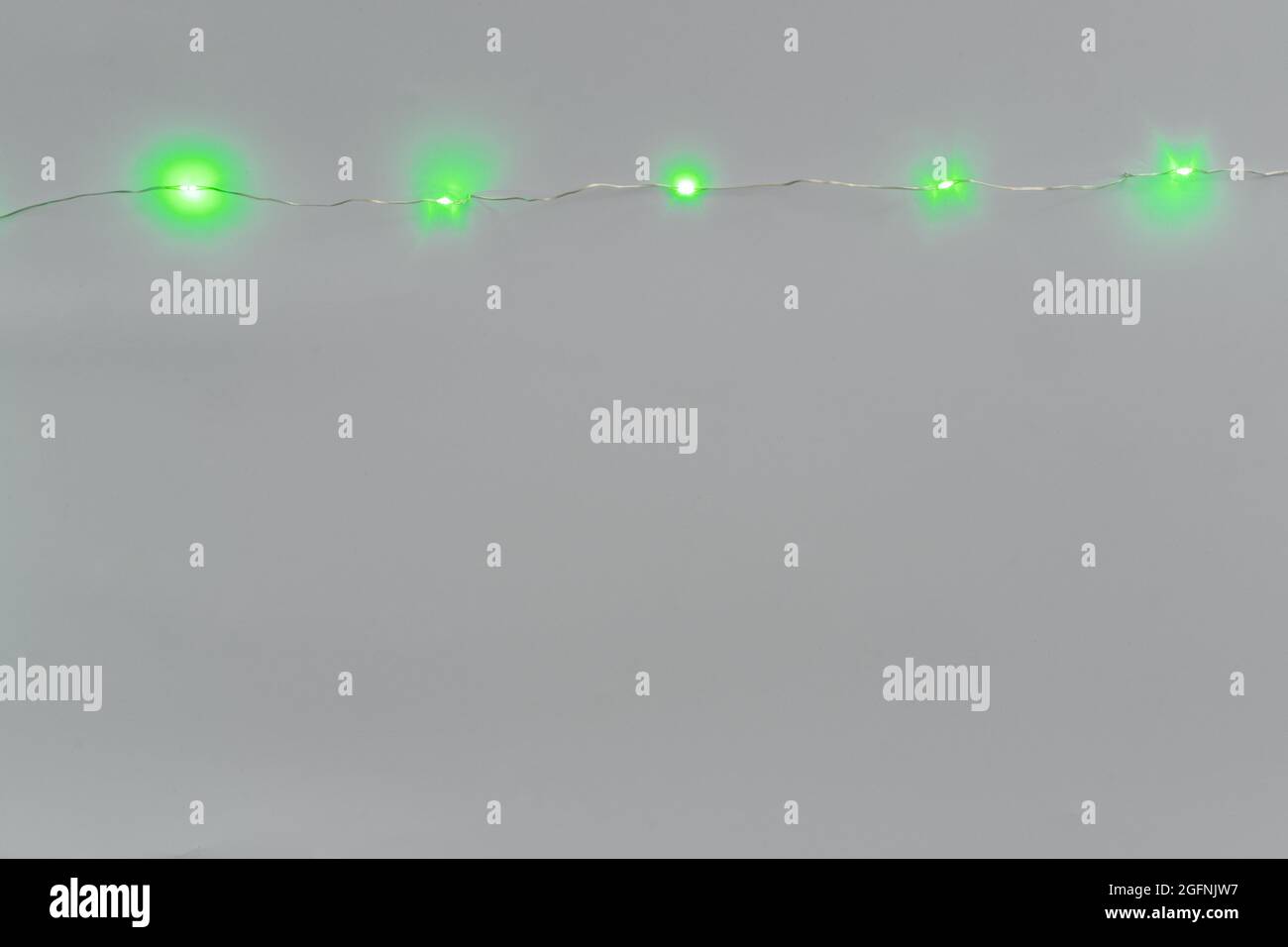 Green color illuminated garland on light gray background Stock Photo ...