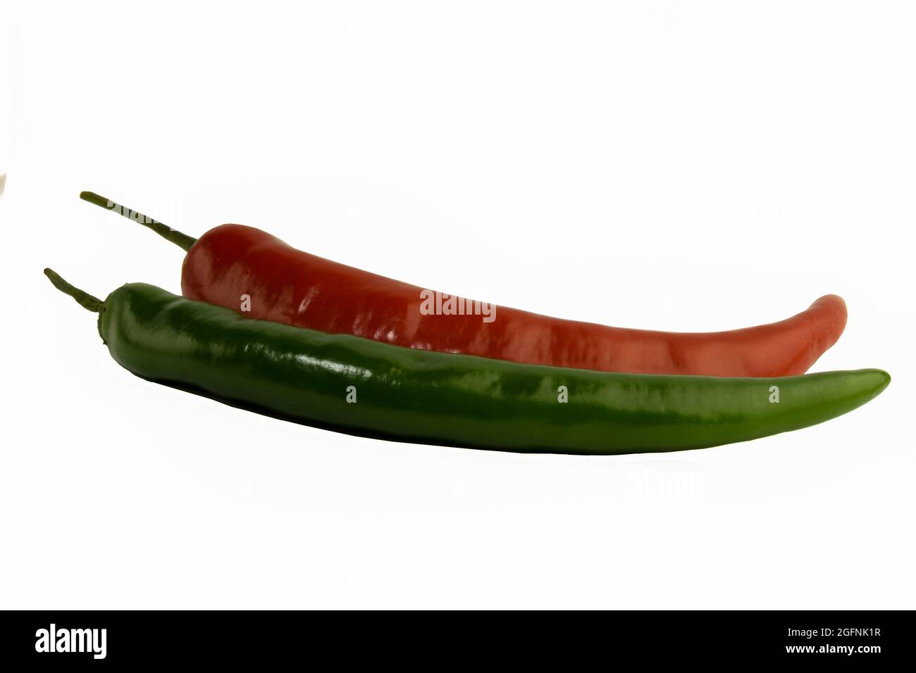 Two fresh red and green pods of chili pepper close up on a white ...