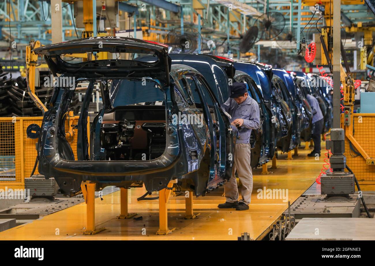 Workers assemble cars produced at a factory of Haima Automobile in ...