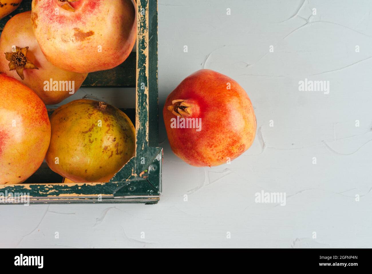 Fresh pomegranates in an old box on wooden background Stock Photo - Alamy