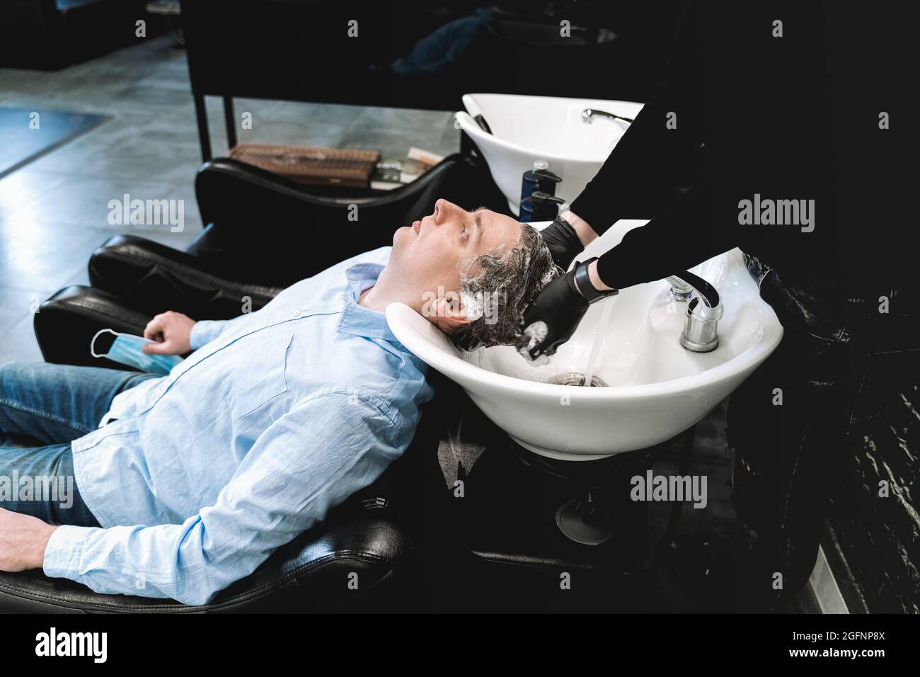 Visit to the barbershop. Young stylish man, businessman makes ...