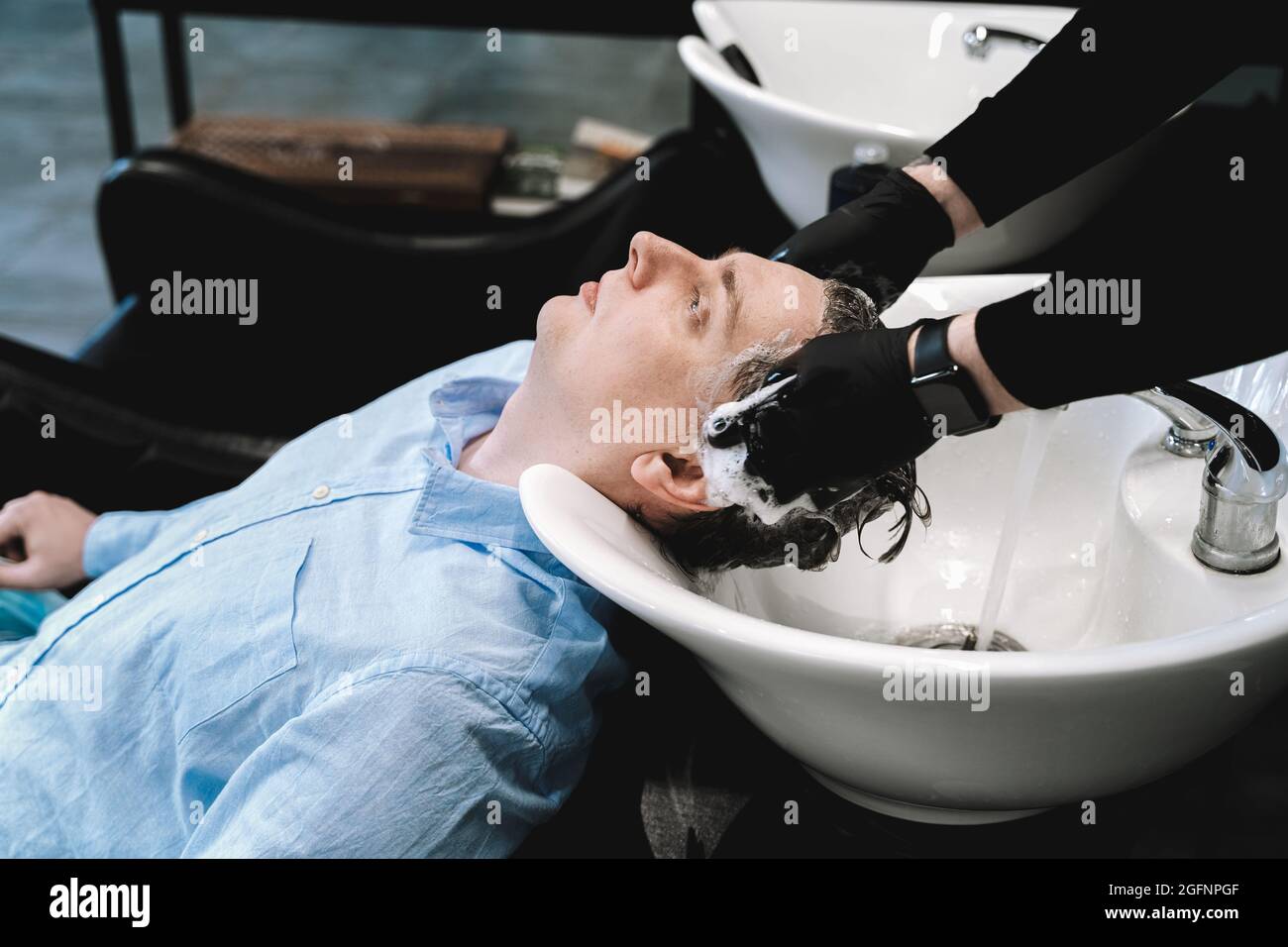Visit to the barbershop. Young stylish man, businessman makes ...