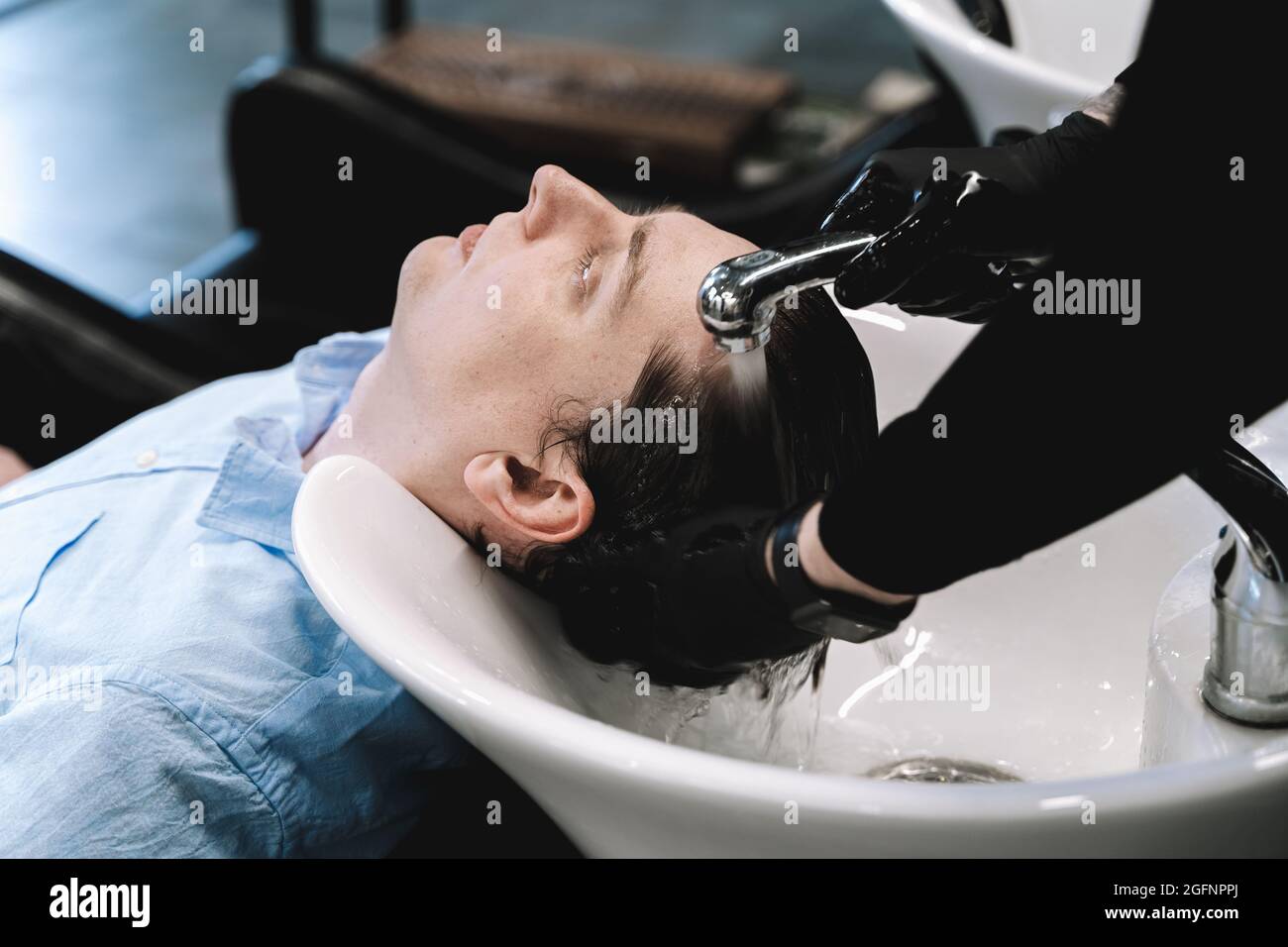 Visit to the barbershop. Young stylish man, businessman makes ...
