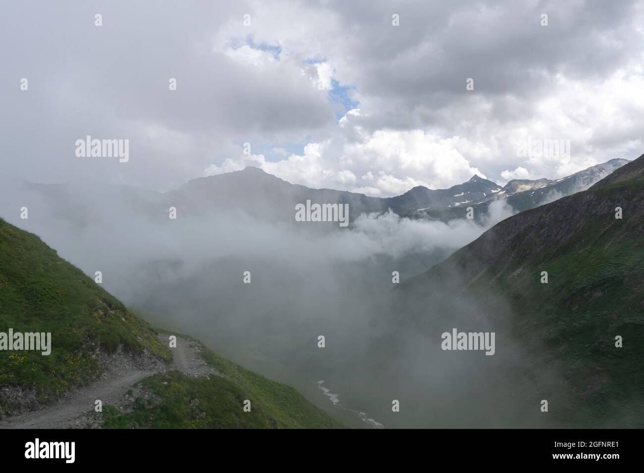 Landscape view of Alps. Peaks cover by clouds and fog because of stormy ...