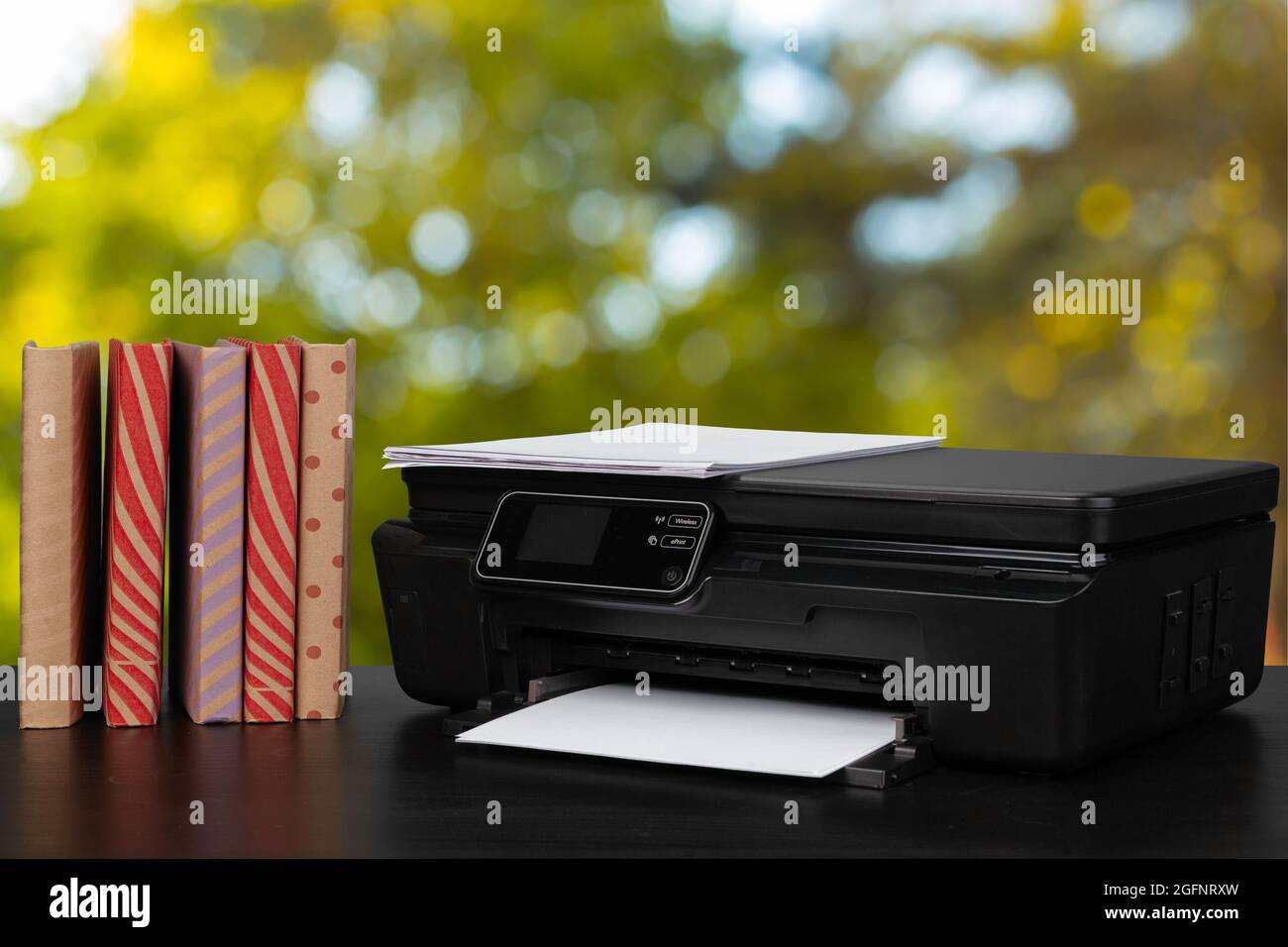 Stack of books and home printer against blurred background Stock Photo ...